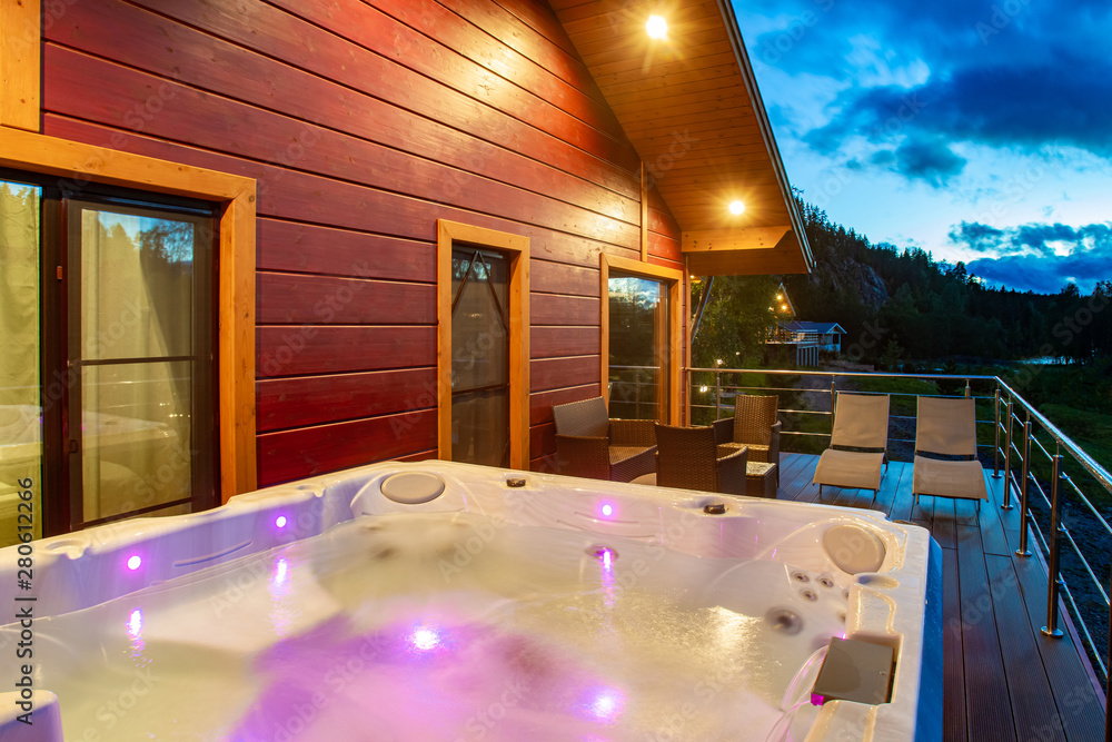 Spa pool with lighting on the balcony of the cottage. spa-zone. Water ...