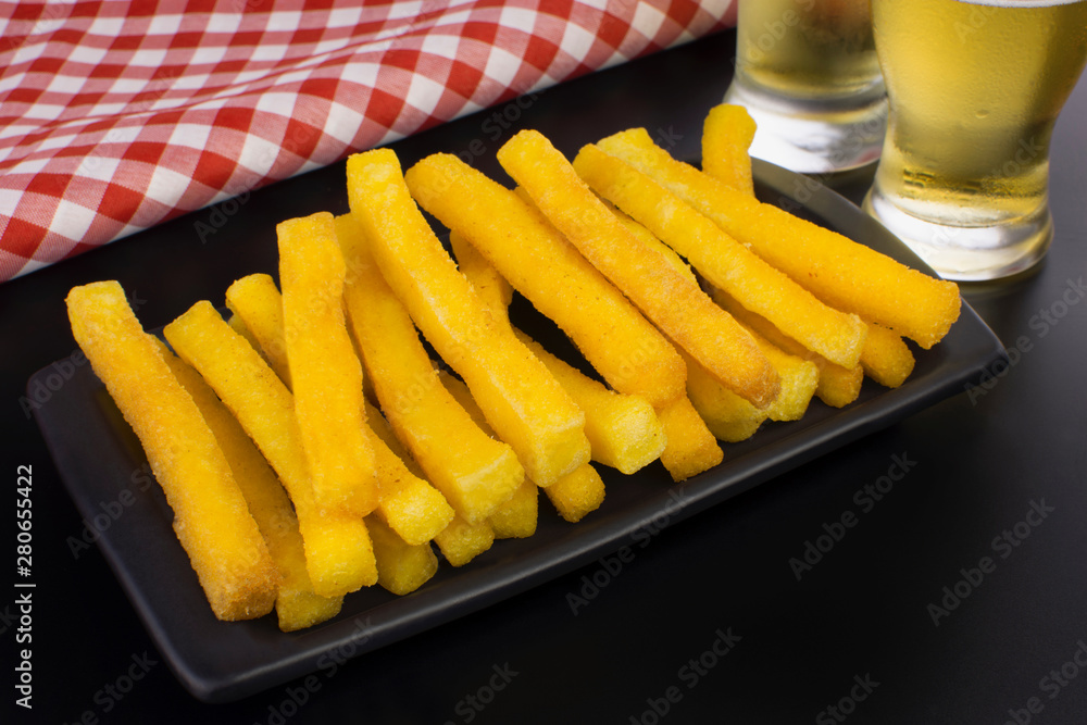 Traditional Brazilian recipe fried polenta in black background with 2 ...