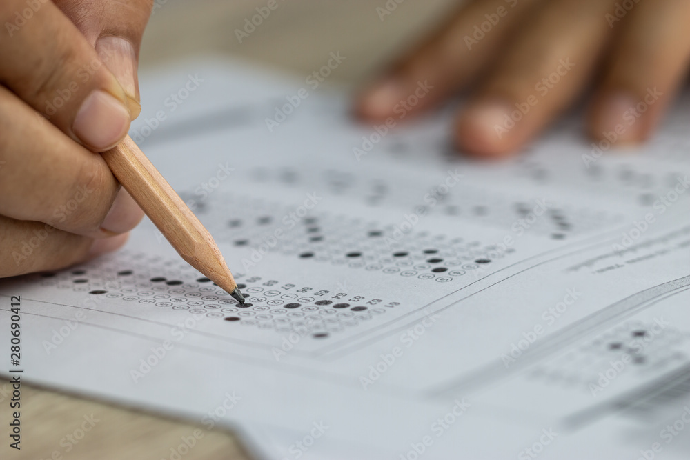 Foto de School Students hands taking exams, writing examination holding ...