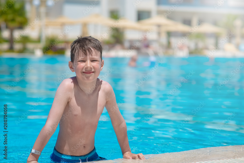 Happy smiling Caucasian boy having fun in swimming pool at resort on ...