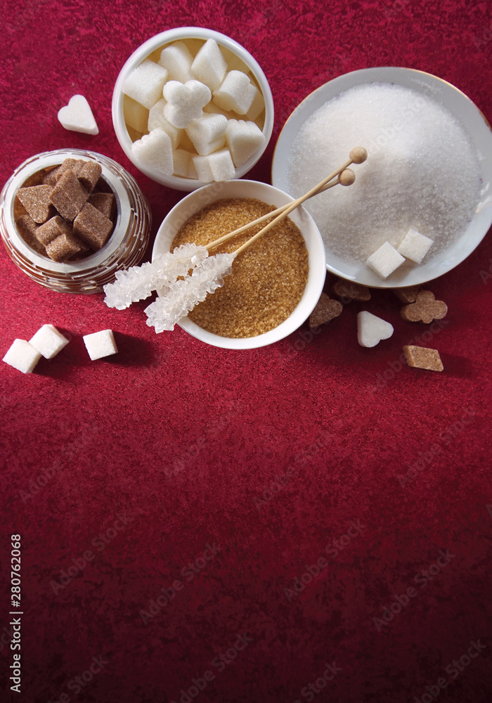 Various types and shapes of sugar on red background with empty space ...