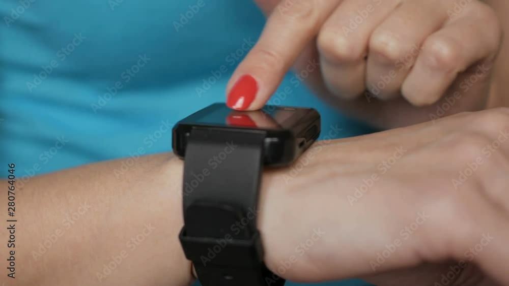 Woman using her smartwatch touchscreen wearable technology device ...
