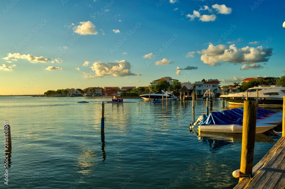 Salida del sol sobre el mar en Cancún, Quintana Roo. Postes de madera ...