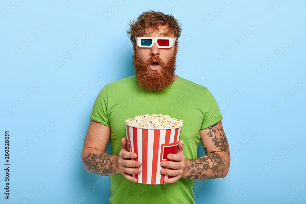People and pastime concept. Scared bearded ginger man watches film ...