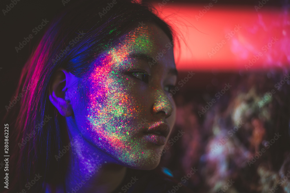 Beautiful young woman dancing and making party with fluorescent ...