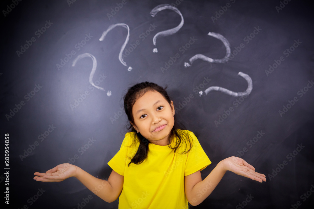 Confused little girl standing with question marks Stock Photo | Adobe Stock