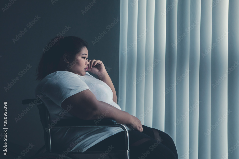Disabled fat woman crying near the window Stock Photo | Adobe Stock