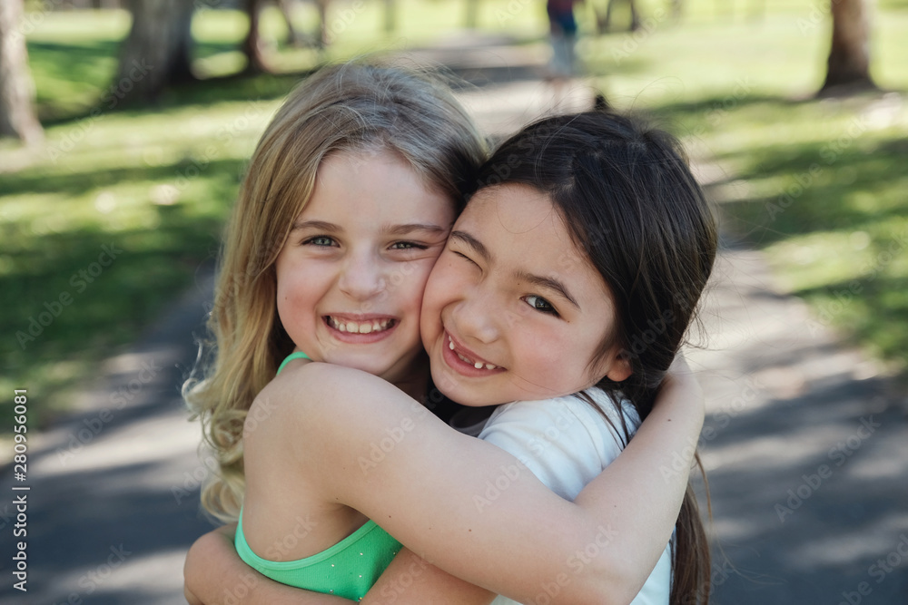 Happy and healthy multiethnic young little girls hugging and smiling in ...