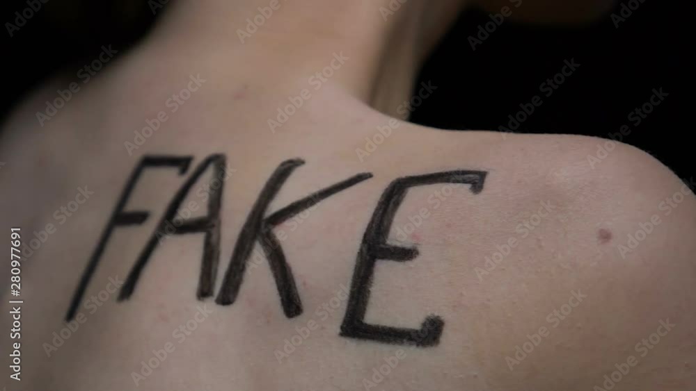 Fake written on female body closeup, bullying victim turning back ...