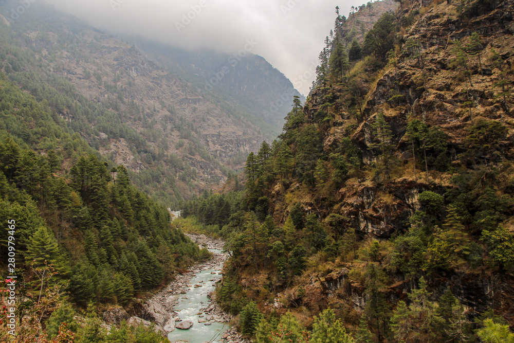 Dudh Koshi snow river (or Dudh Kosi river) flows in mountain valley ...