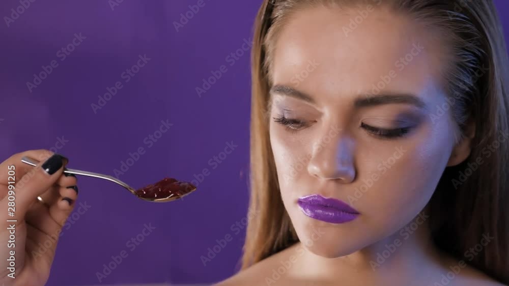 Portrait of young beautiful girl holding a open jar glass of jam with ...