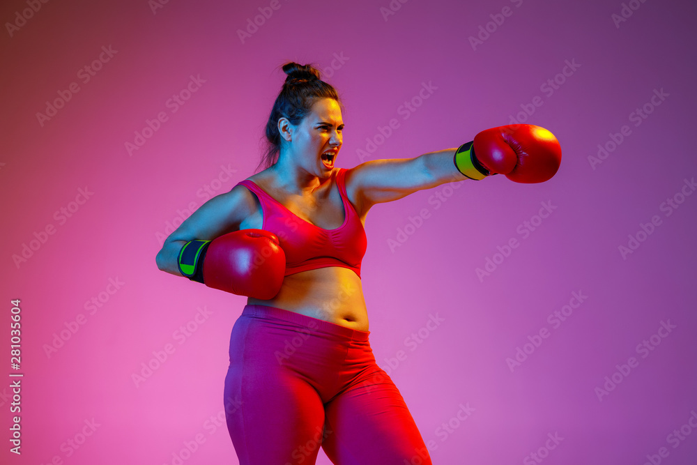 Young caucasian plus size female model's doing exercises on gradient ...