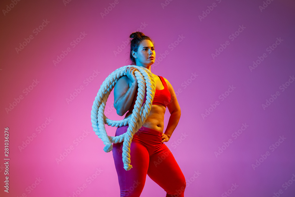 Young caucasian plus size female model's doing exercises on gradient ...