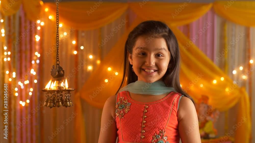 Indian girl with a smiling face looking at diyas - folding hands in ...
