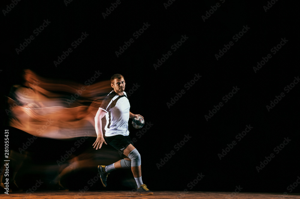 Caucasian young handball player in action and motion in mixed lights ...