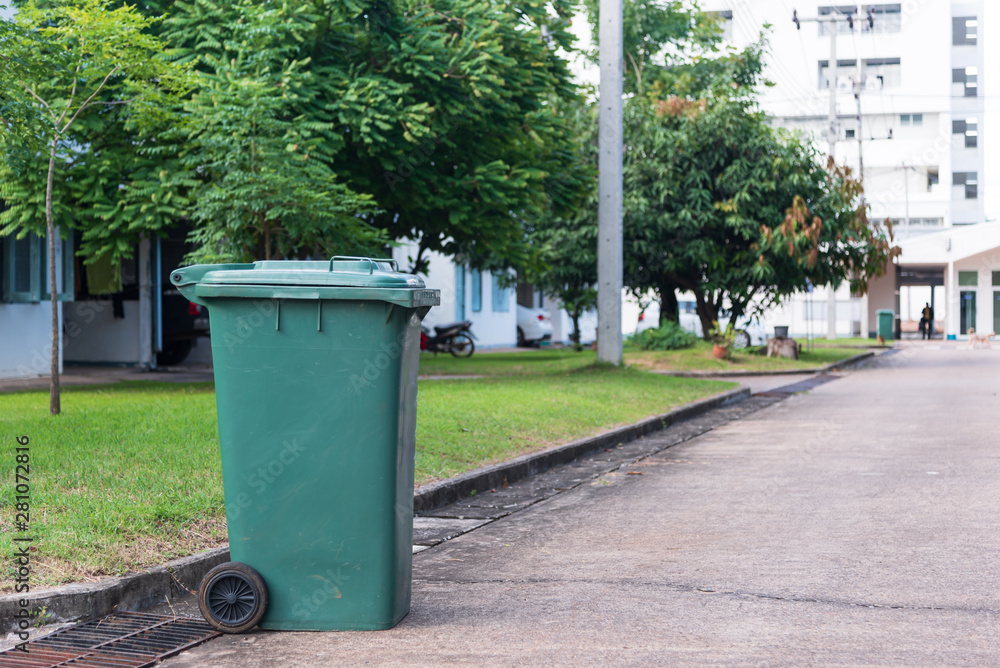 Green garbage bin in front of the house.Public trash on the side of the ...
