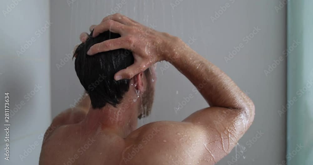 Man taking a shower washing hair under water falling from rain ...