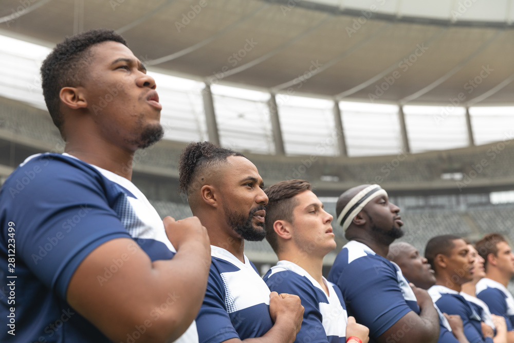 Group of diverse male rugby players taking pledge together in stadium ...