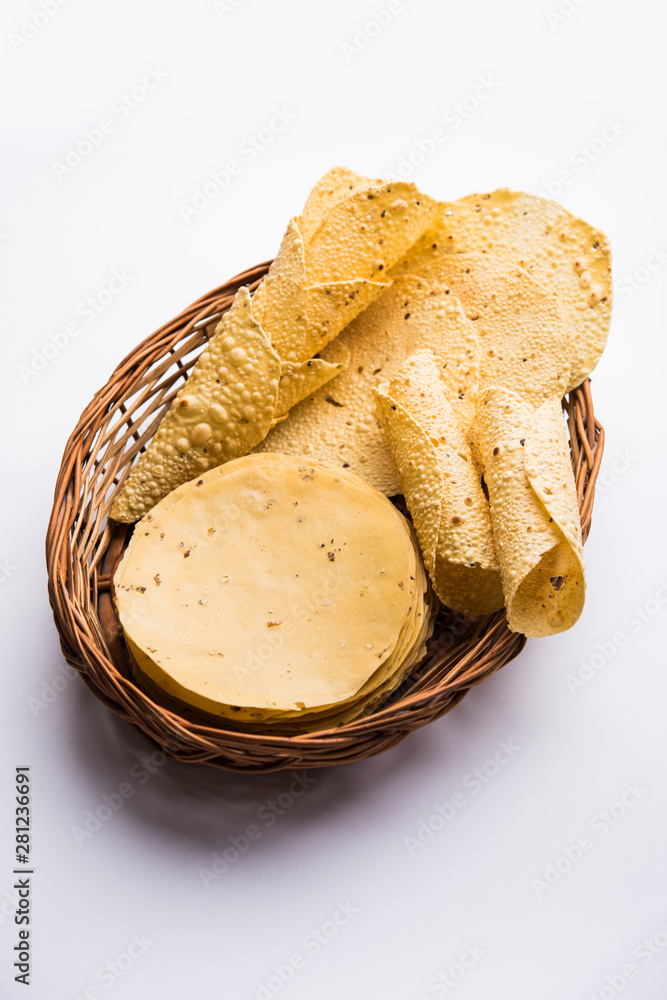 Gujarati papad or papadum in raw dried form with roasted cone, roll and ...