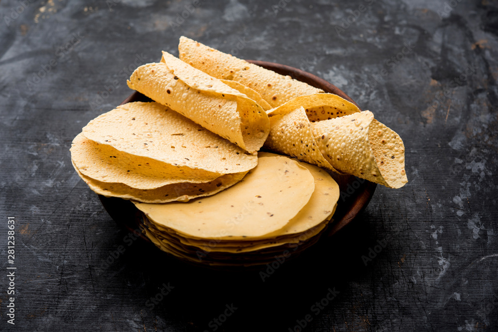 Gujarati papad or papadum in raw dried form with roasted cone, roll and ...