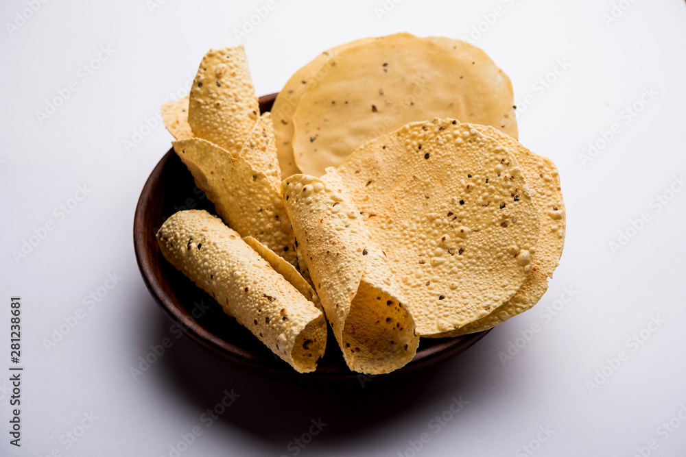 Gujarati papad or papadum in raw dried form with roasted cone, roll and ...