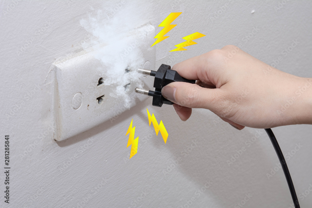 Dangerous high voltage. Twin electrical socket damaged with hand's man ...