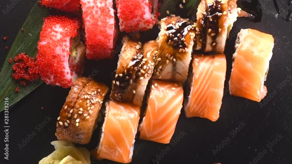 Vidéo Stock Sushi roll set on black slate background. Rotated ...