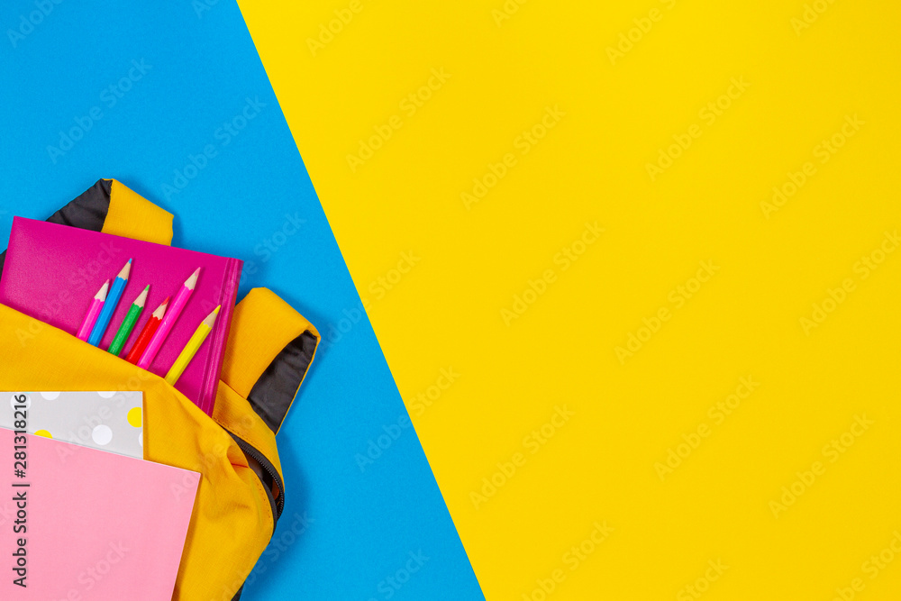 Back to school concept. Yellow backpack with school supplies on yellow ...