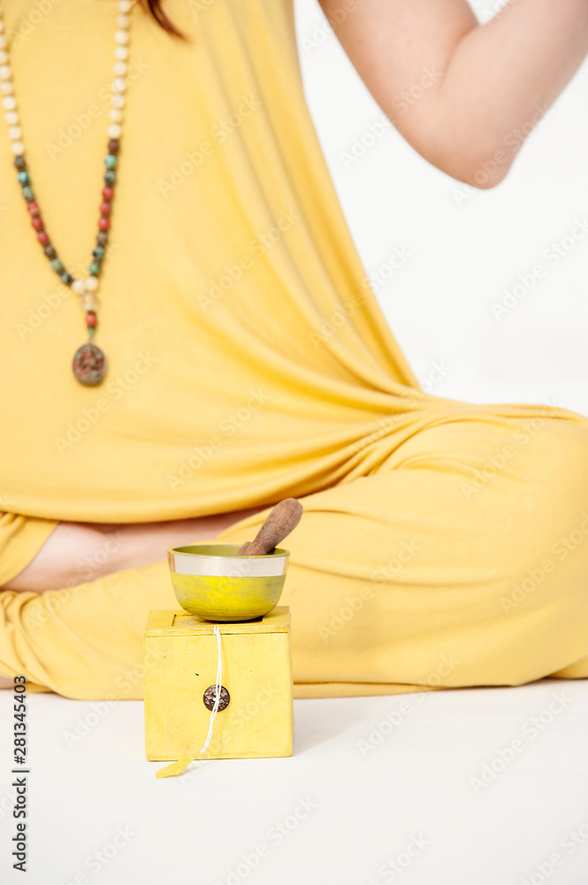 Spiritual woman in yellow outfit photographed on a white background ...