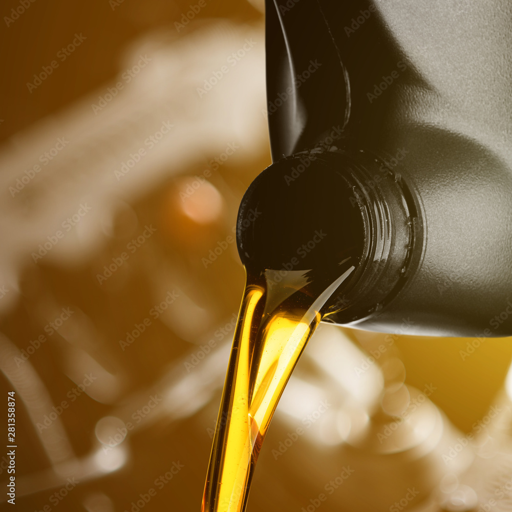 Pouring oil lubricant motor car from black bottle on engine background object transportation ...