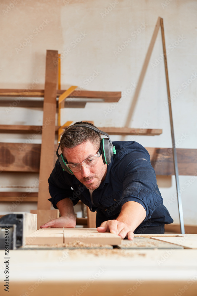 Carpenter saws wood with circular saw Stock Photo | Adobe Stock