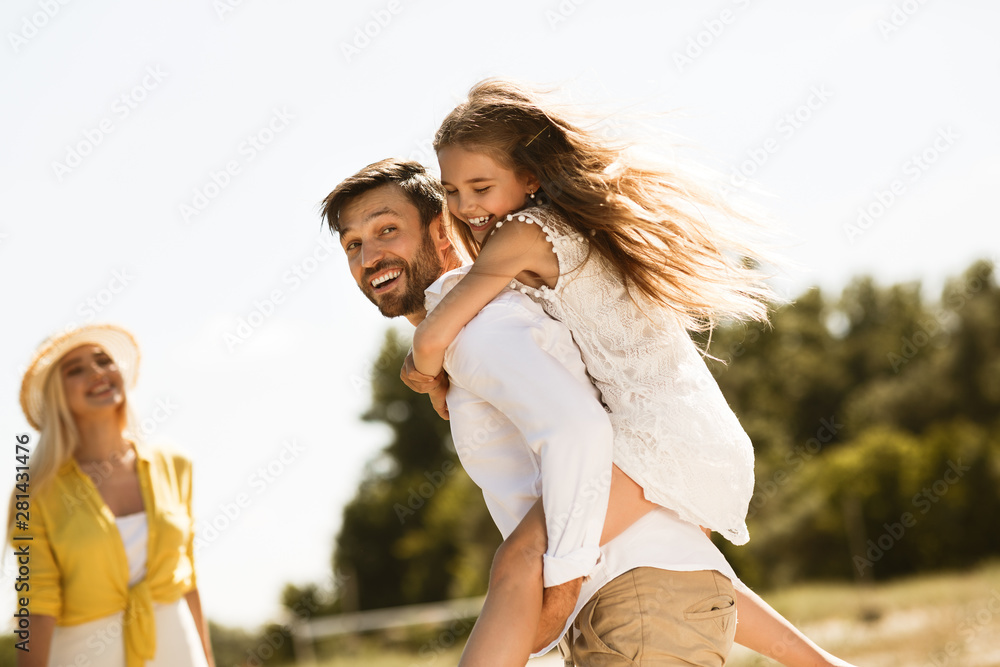 Happy father carrying his daughter on back outdoors Stock Photo | Adobe Stock