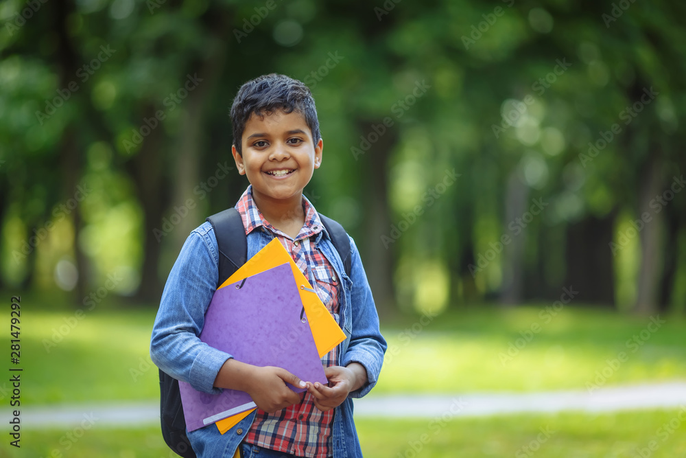 Outdoor portrait afro american happy school boy with books and backpack ...
