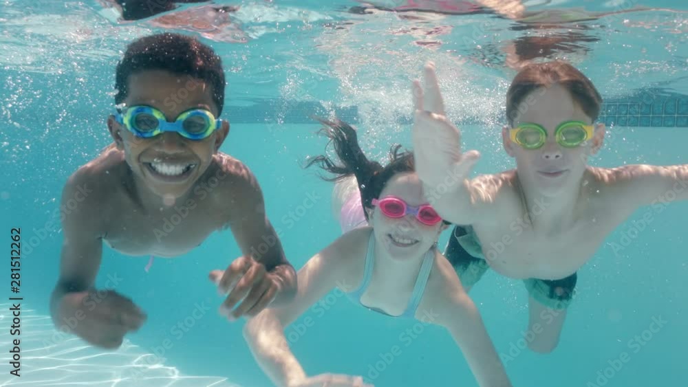 happy children swimming underwater in pool smiling waving hands kids ...