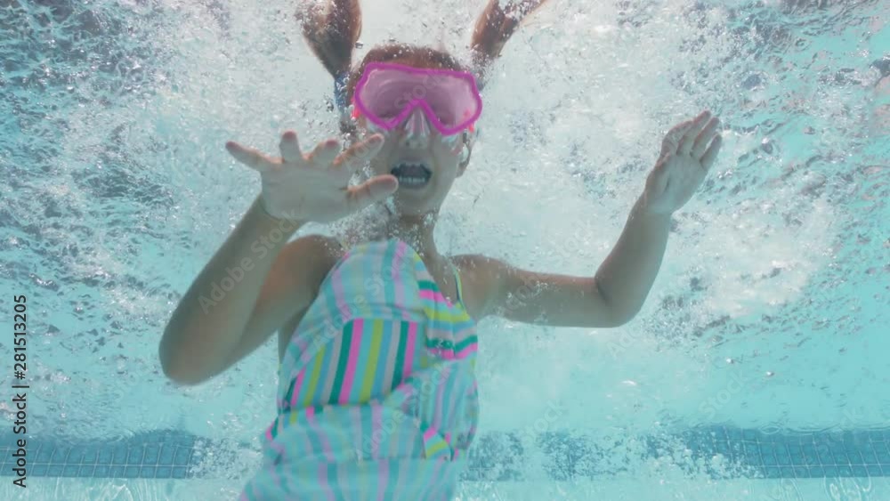 underwater view little girl jumping in swimming pool wearing flippers ...