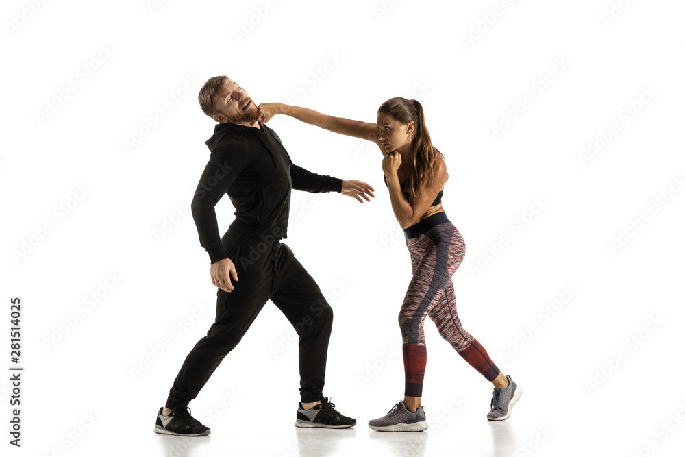 Man in black outfit and athletic caucasian woman fighting on white ...