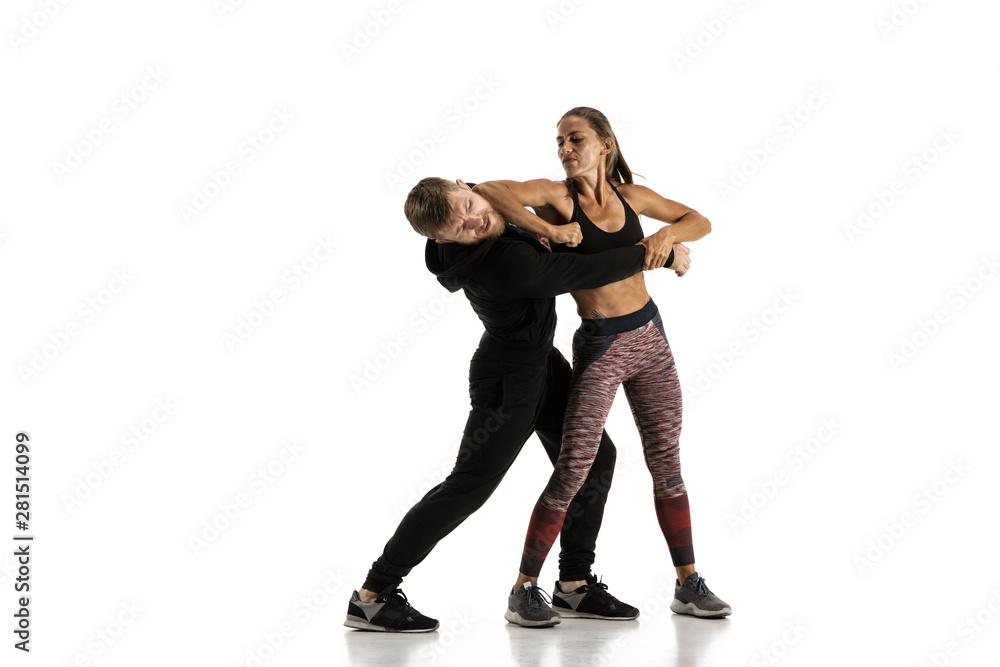 Man in black outfit and athletic caucasian woman fighting on white ...