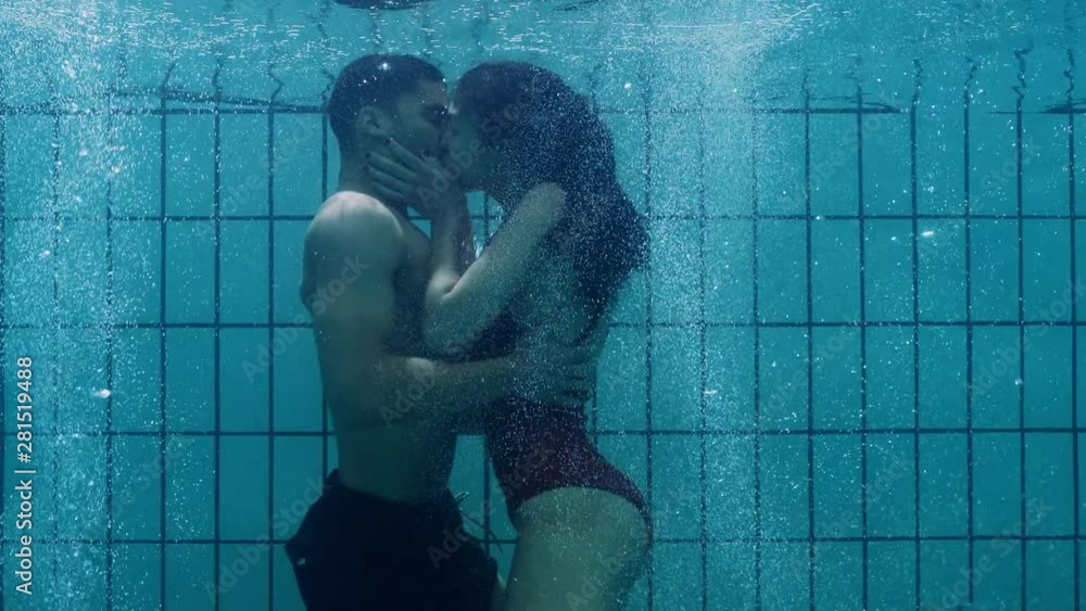 romantic couple kissing underwater in swimming pool young people in ...