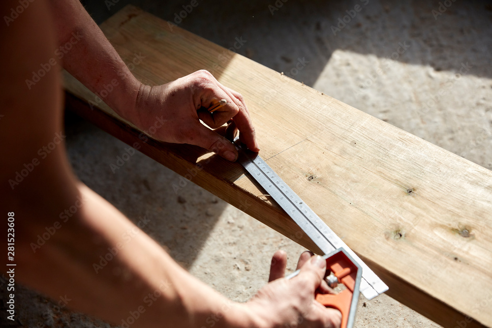 Carpenter measuring plank of wood with metal ruler Stock Photo | Adobe ...
