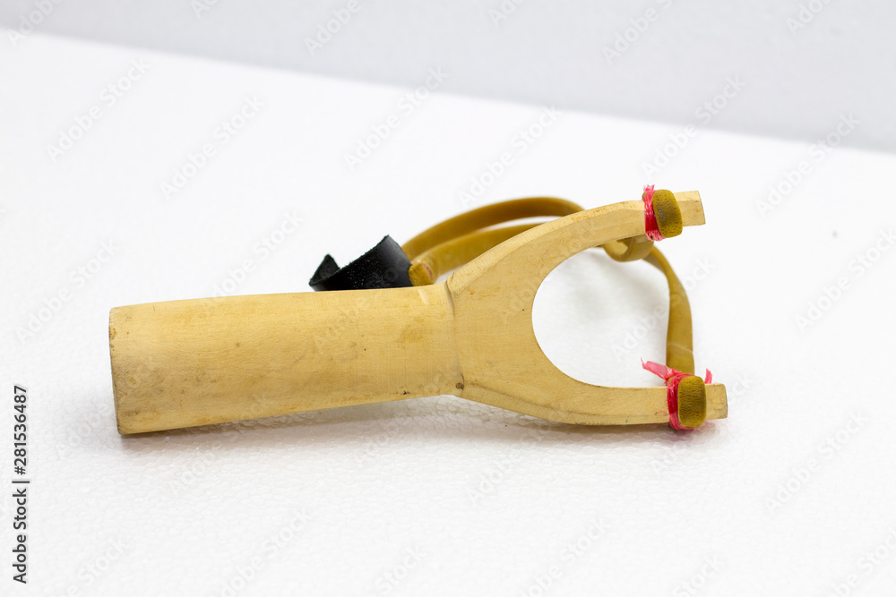 Handmade slingshot catapult. Y-shaped wooden stick with elastic tied ...