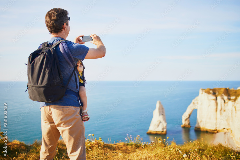 Man carrying his baby in baby carrier and taking a photo of panoramic ...
