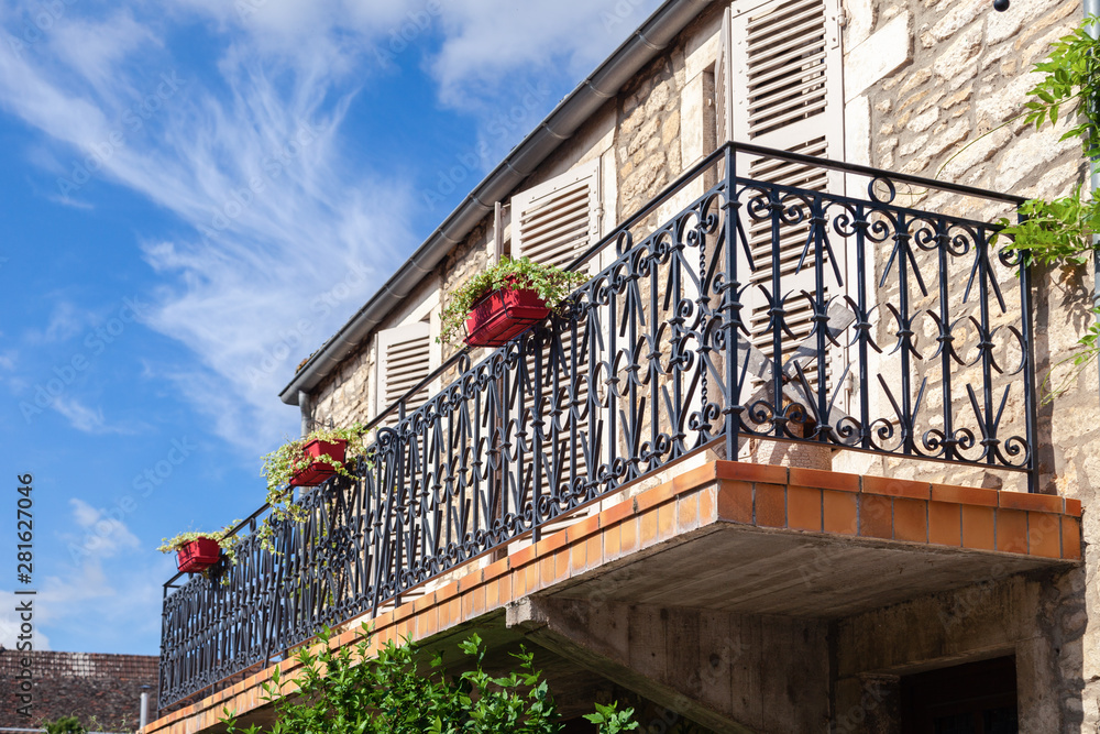 Cozy vintage French balcony with black metal railings, flowers in pot ...