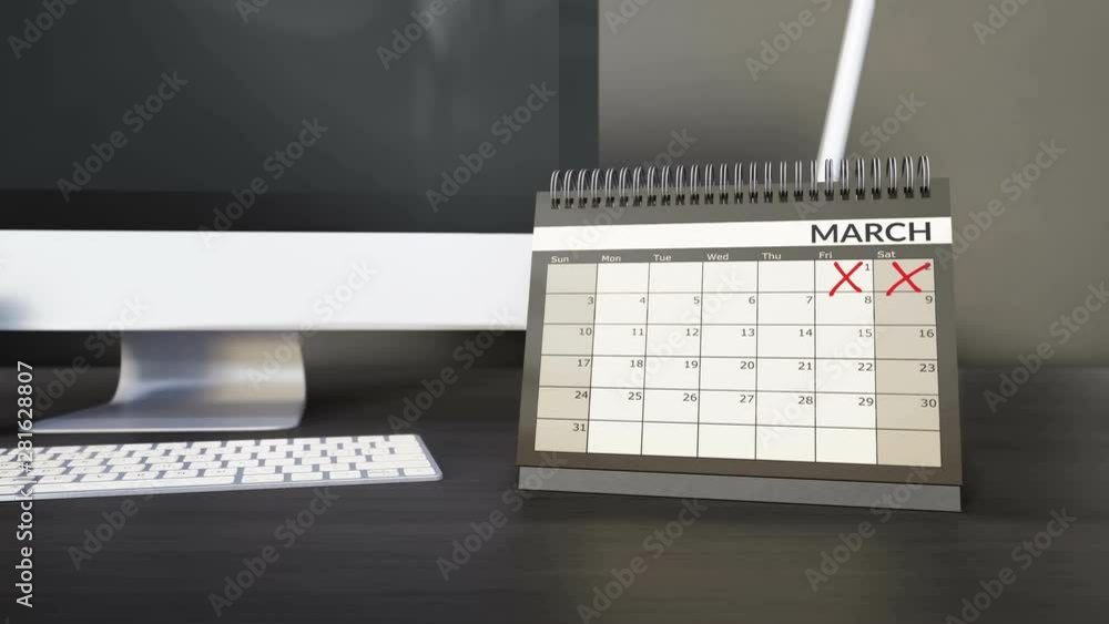 Ticking off dates and months on desk year calendar, computer and ...