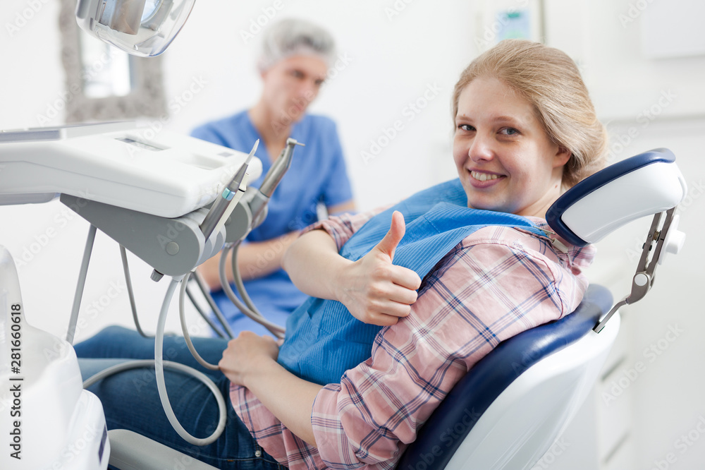 Client woman is sitting satisfied in chair after treatment in dental ...