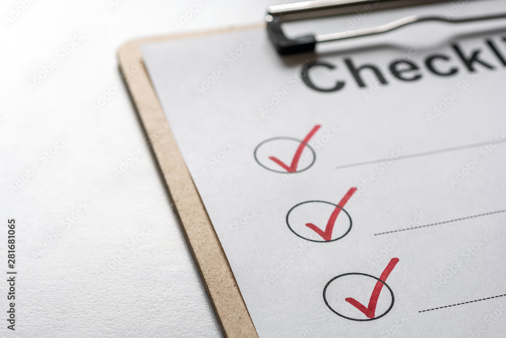 Abgehakte Checkliste auf einem Klemmbrett liegt auf einem hellen ...