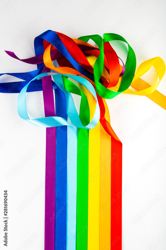 LGBT flag symbol made of satin ribbons on a white background. A rainbow ...
