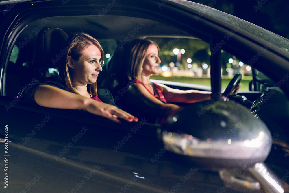 two women females in the car driving at night friends mother and ...