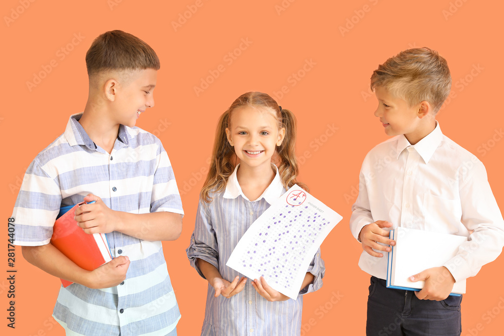 Happy children with answer sheet for school test on color background ...