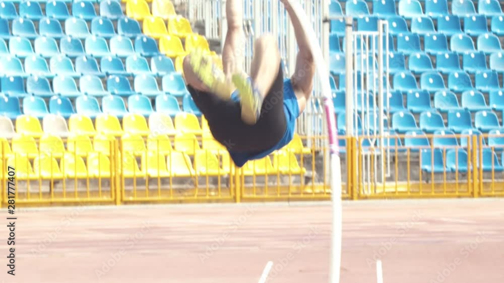 Pole vault - a young man running up and jumping over the bar - stadium ...