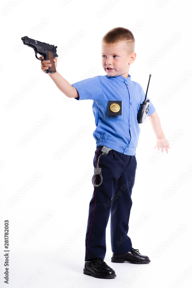 Cute little police boy with smile on face and gun on white background ...